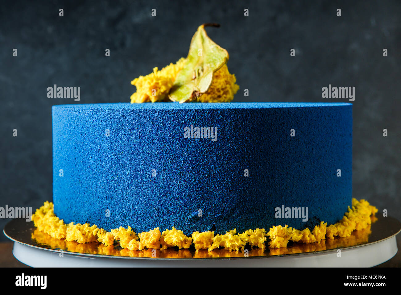 blue round cake decorated with dried pear and pieces of yellow sponge ...