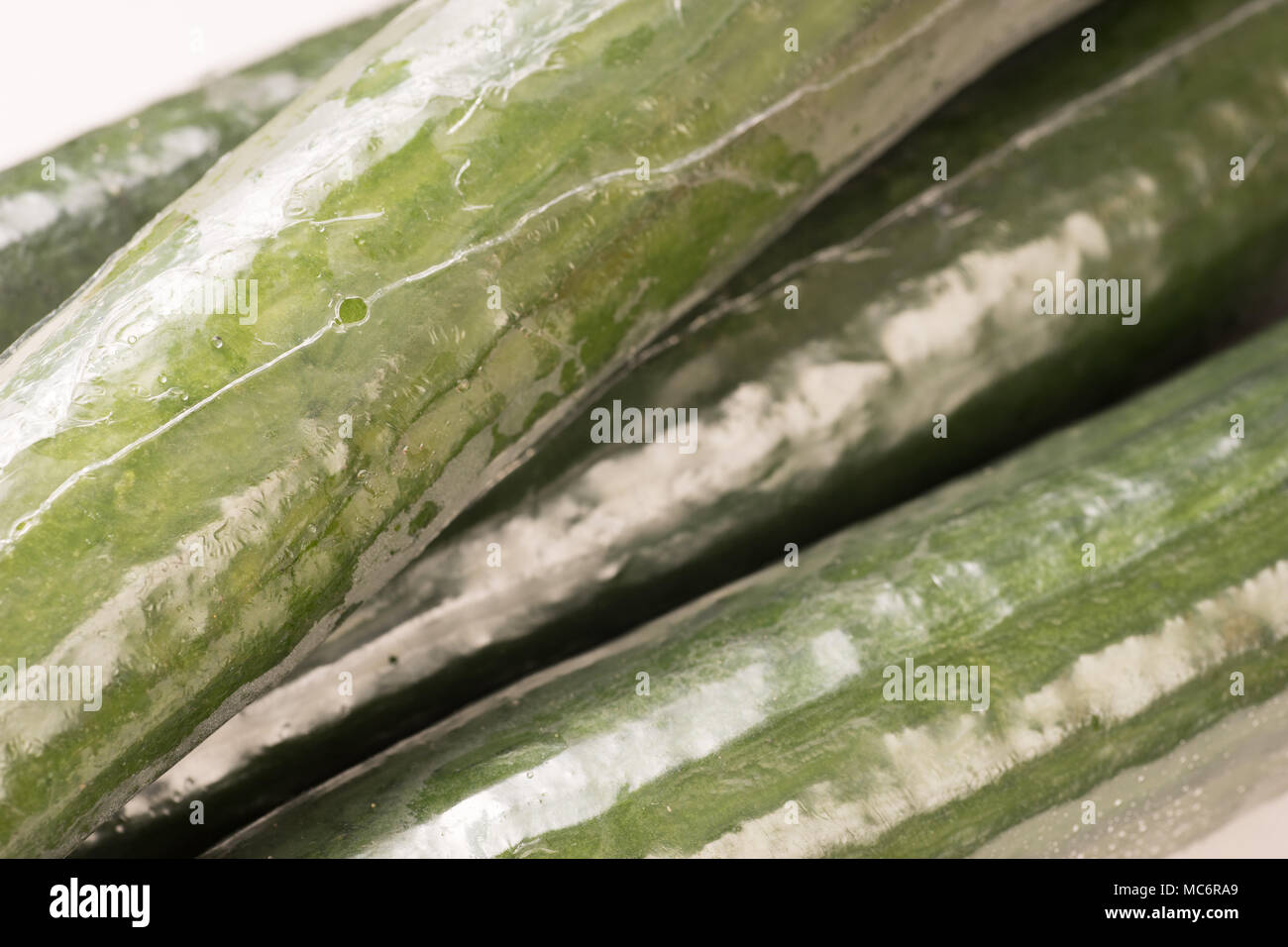 Bunch of cucumber wrapped in plastic films, close up and background ...