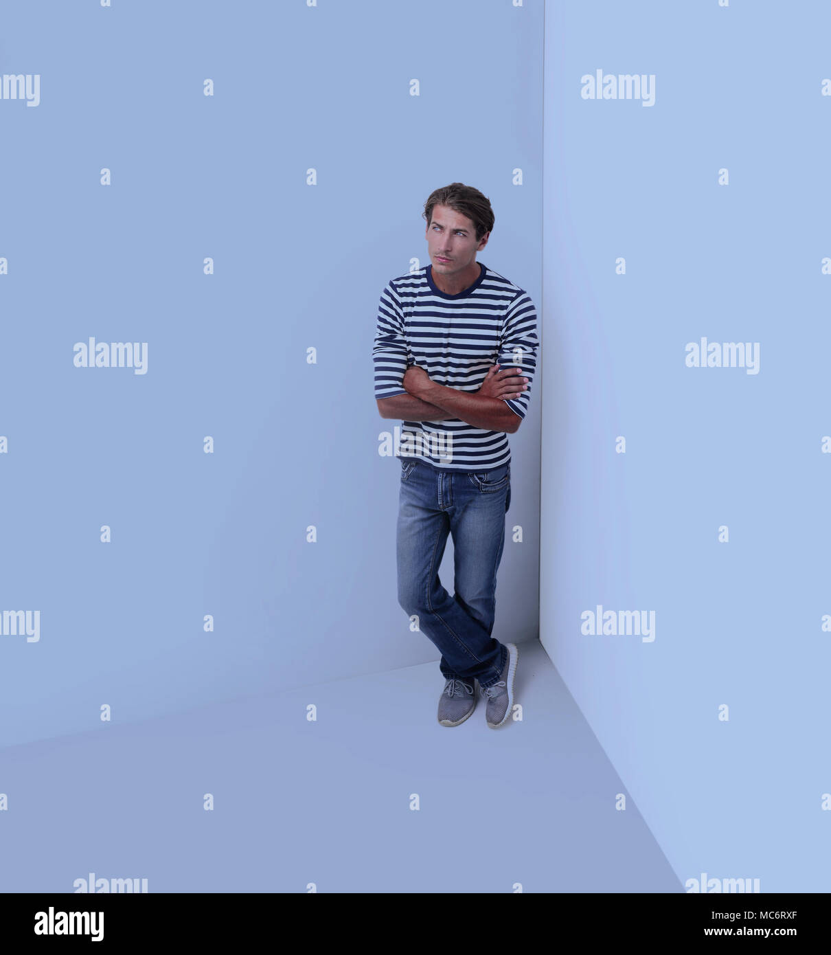 thoughtful man standing in the corner Stock Photo - Alamy