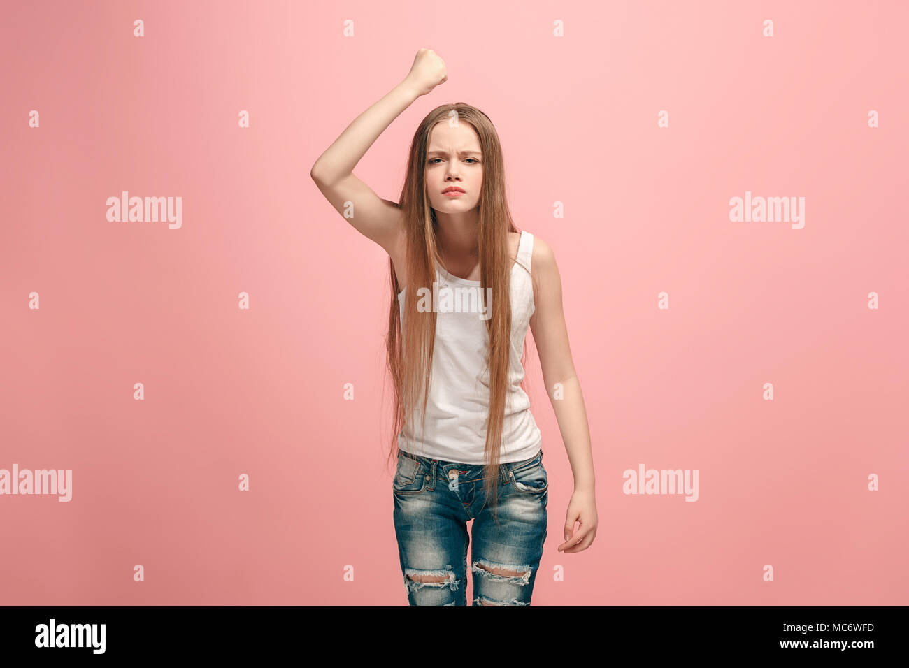 Portrait of angry teen girl on a pink studio background Stock Photo - Alamy