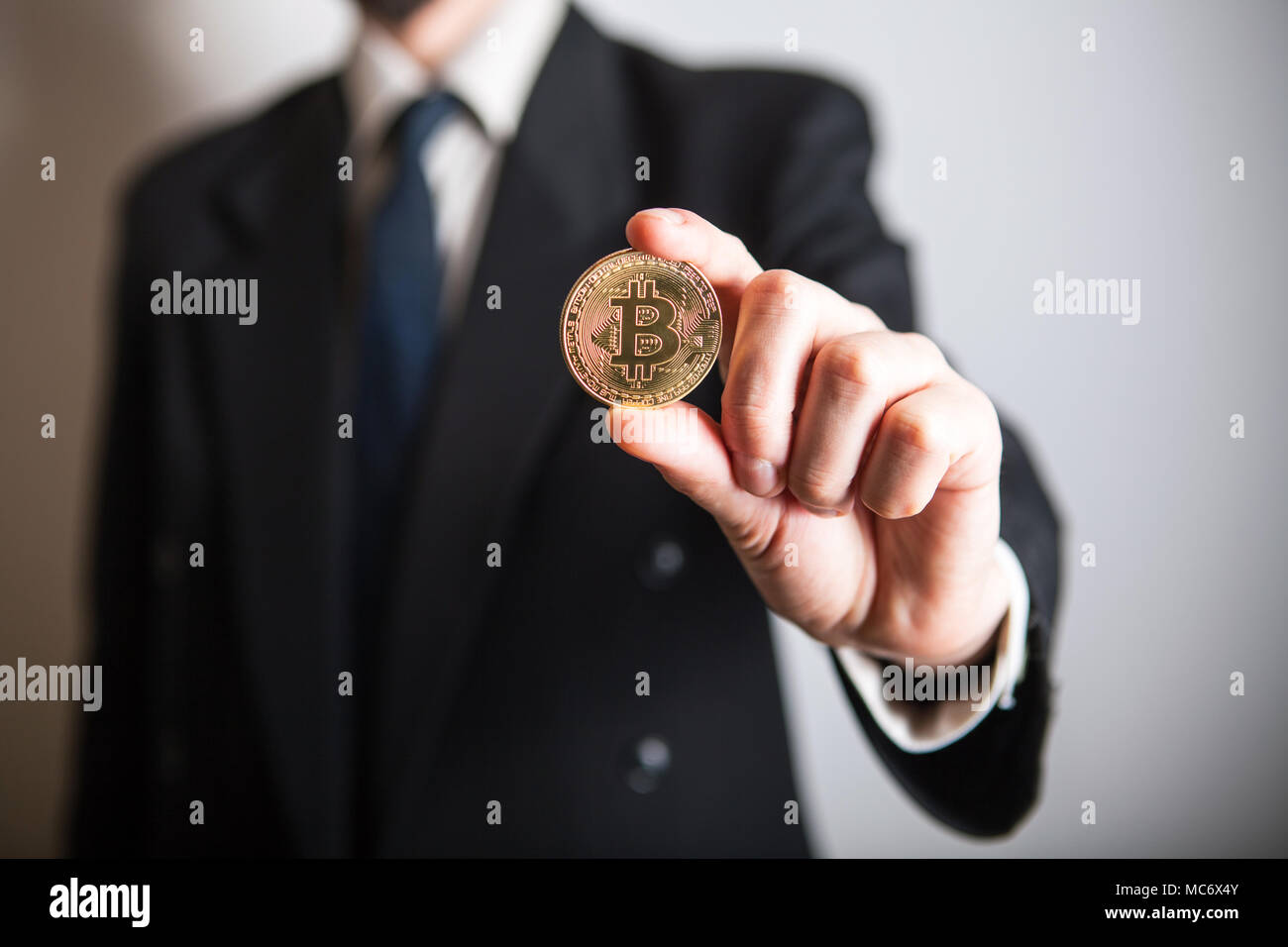 Golden Bitcoin in a man hand, Digitall symbol of a new virtual currency ...