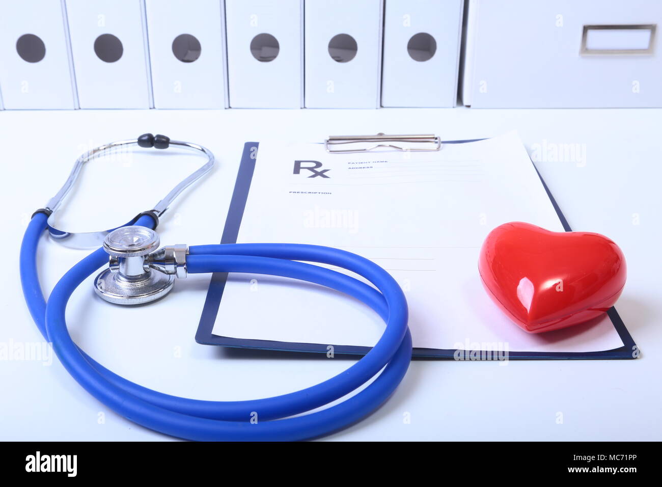 Closeup of medical stethoscope on a rx prescription, red heart isolated ...