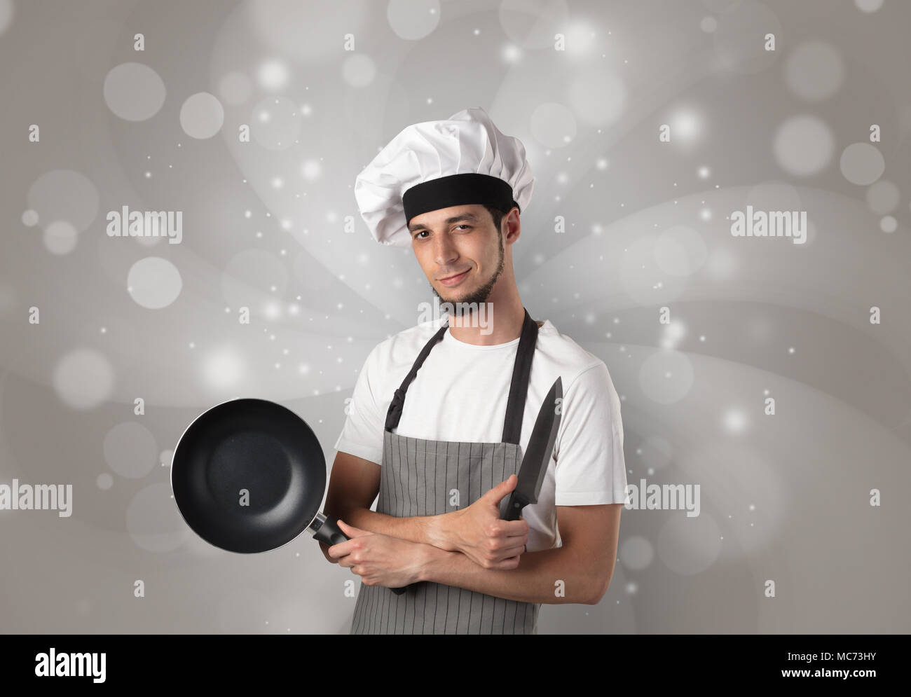 Male cook with kitchen tools and shiny grey wallpaper Stock Photo - Alamy