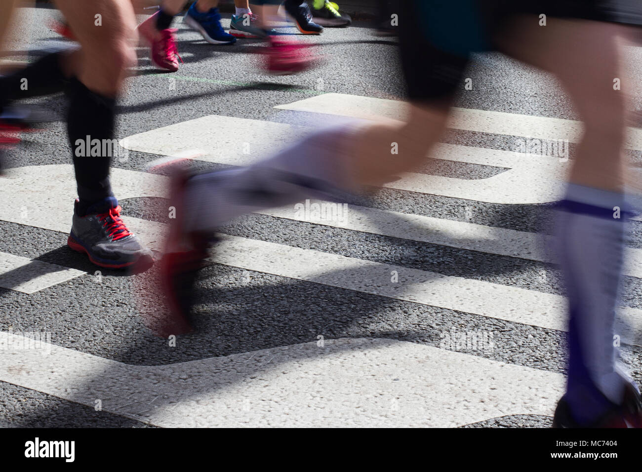 closeup side view of marathon runners feet and legs with motion blur ...