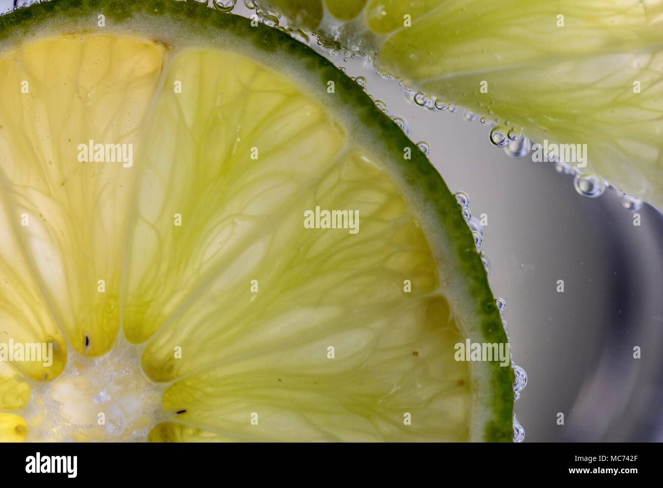 Macro Lime Slices in Sparkling water with bubbles Stock Photo - Alamy