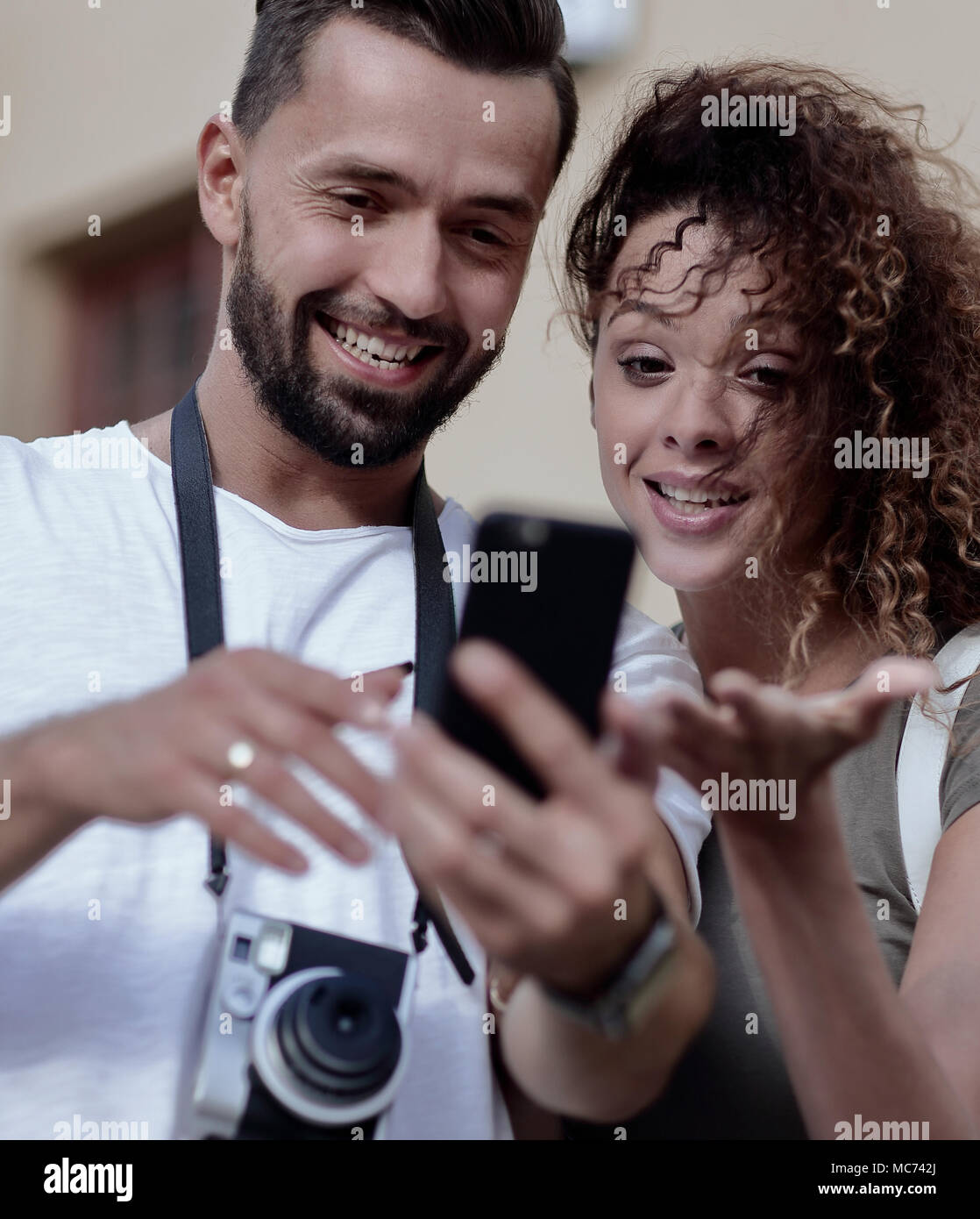 Happy young couple searching for location both on mobile phone Stock ...