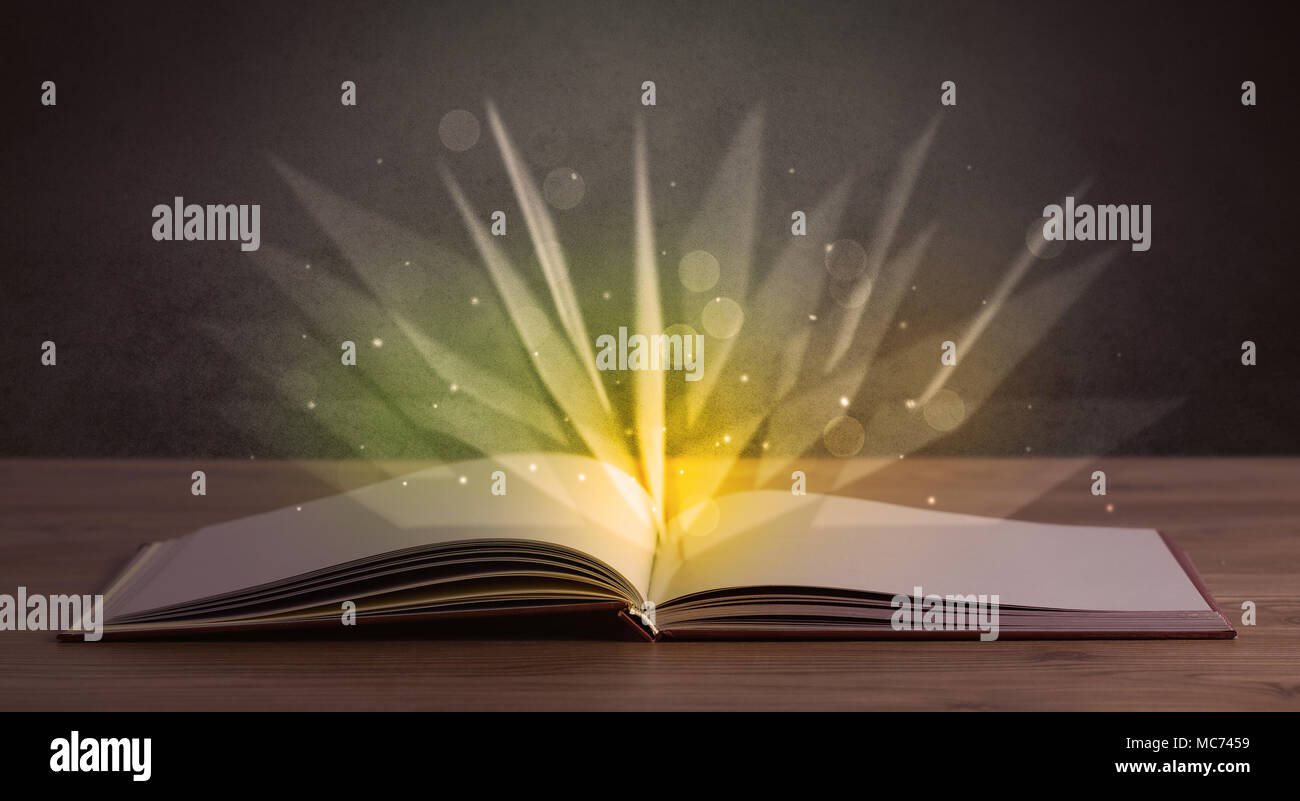 Yellow lights spreading from an open book Stock Photo - Alamy