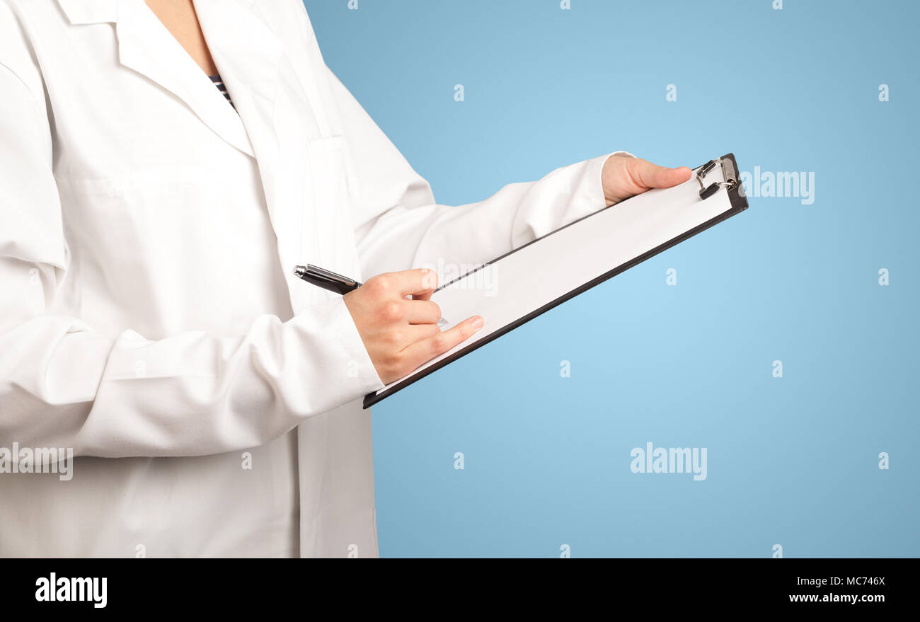 Female doctor holding notepad with blue background Stock Photo - Alamy