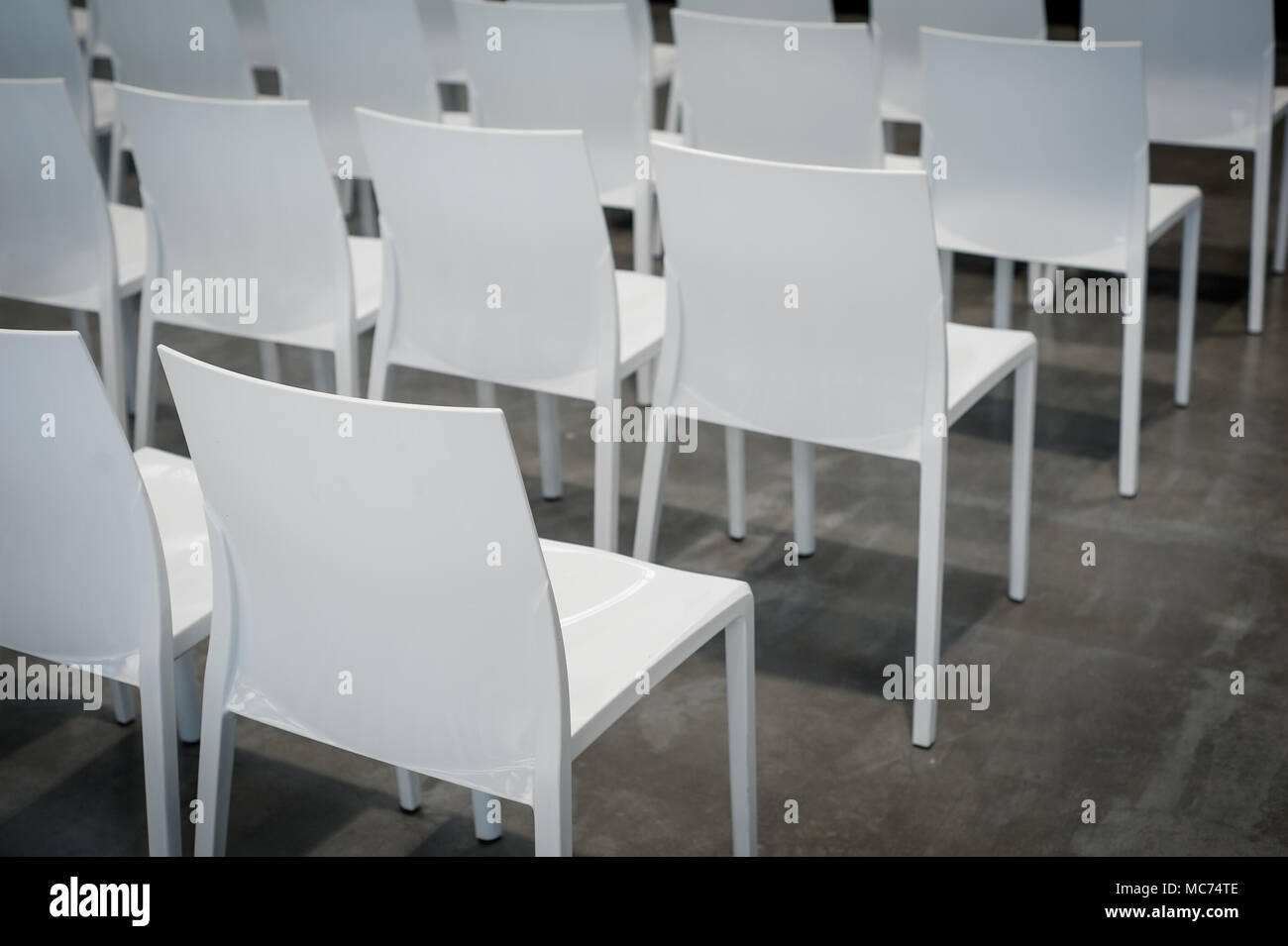 Sitting in white plastic chairs hi-res stock photography and images - Alamy