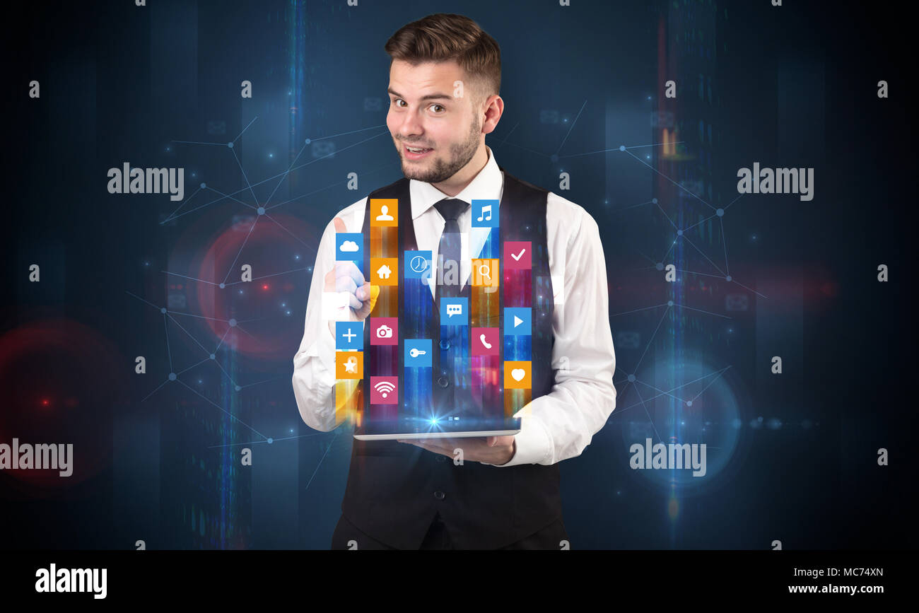 Elegant businessman holding tablet with hologram application icons and ...
