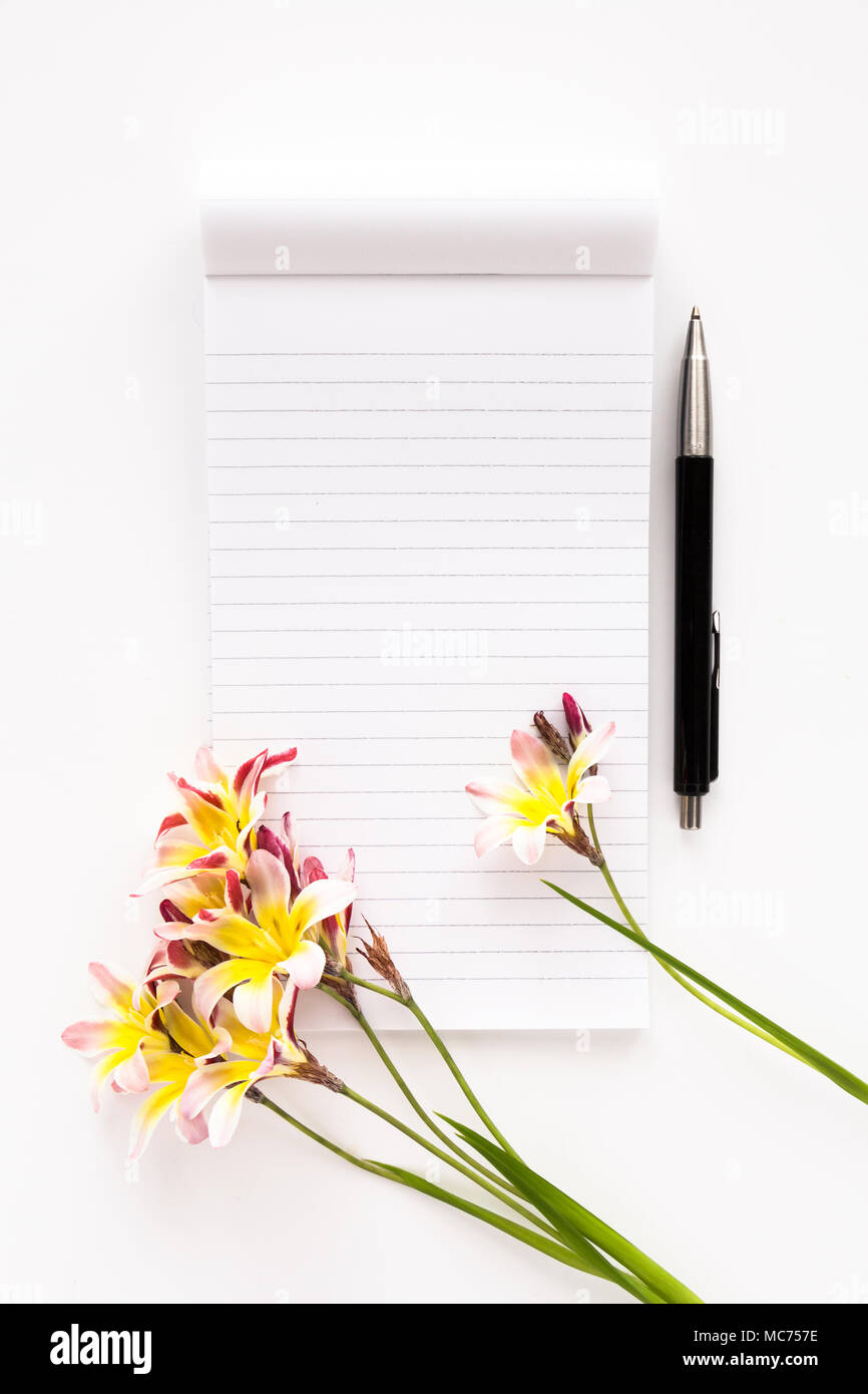 Colorful spring flowers, with blank open notepad for text and pen, on ...
