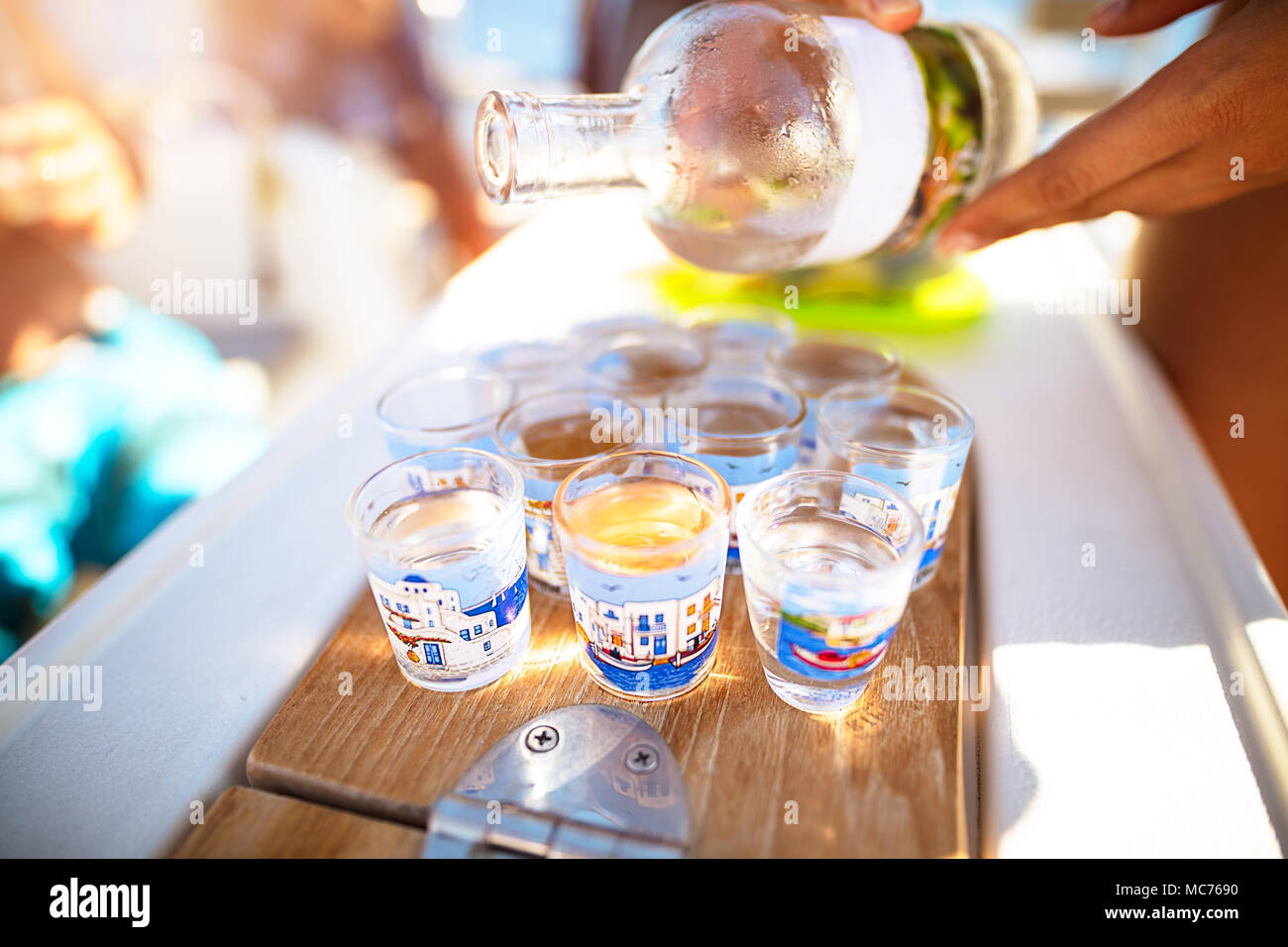 Party on the beach, refill glass with alcoholic beverage, drinking ...