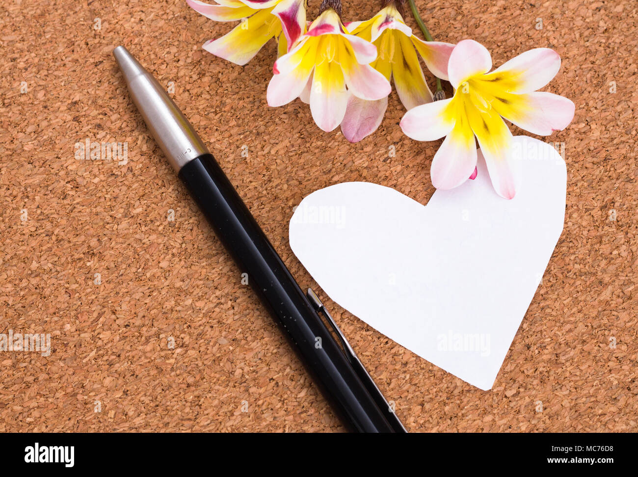Blank note in shape of heart with copy-spce and flowers, on cork ...