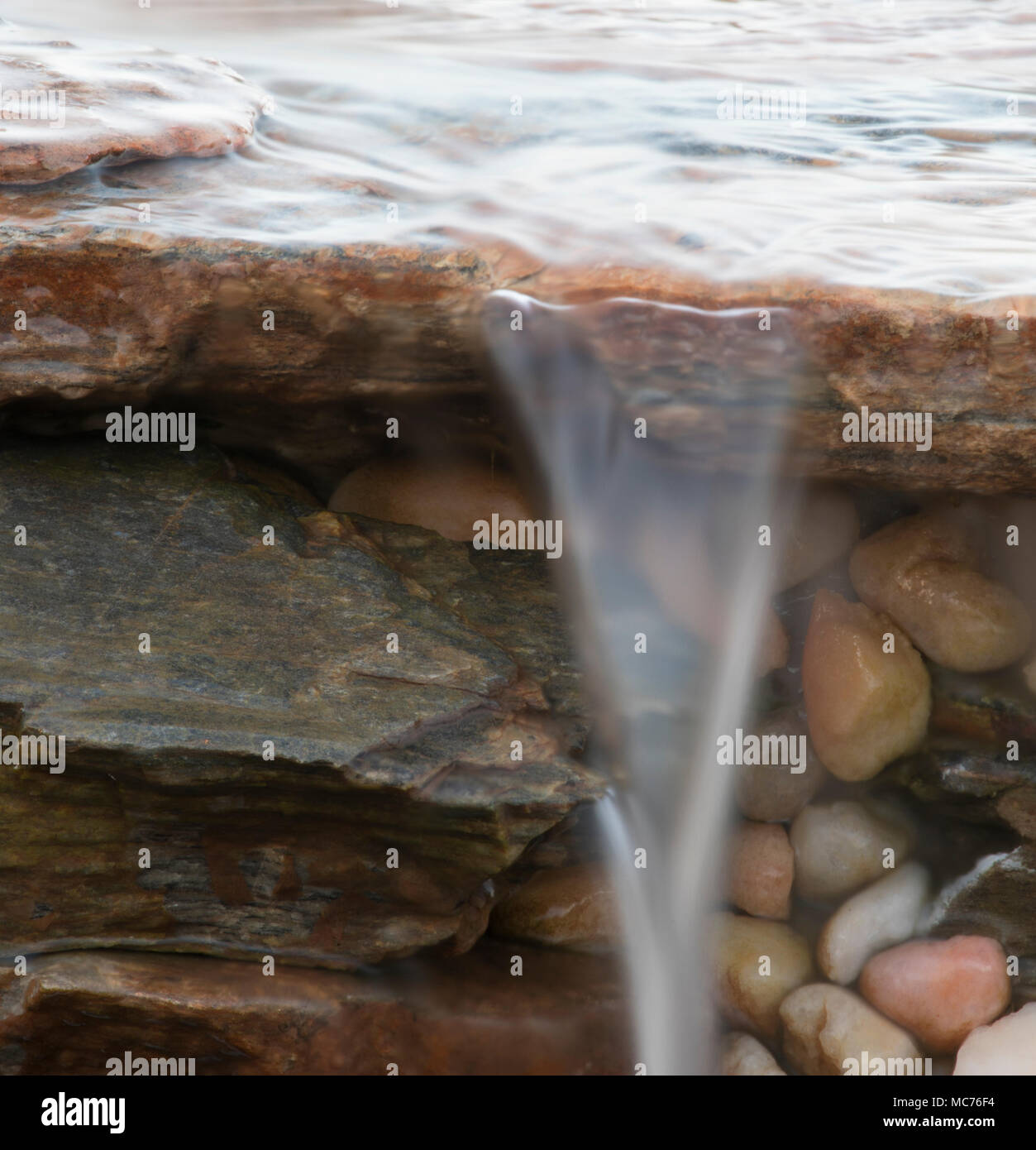 Single line of water running down a small rocky waterfall Stock Photo ...