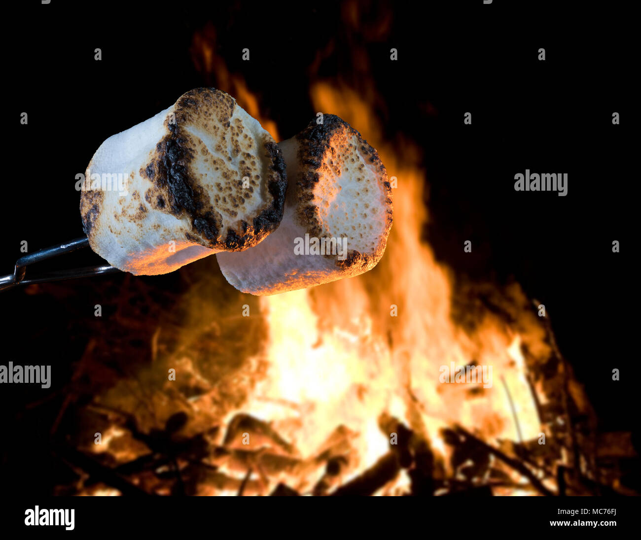 Two marshmallows being roasted over a campfire to make smores Stock ...