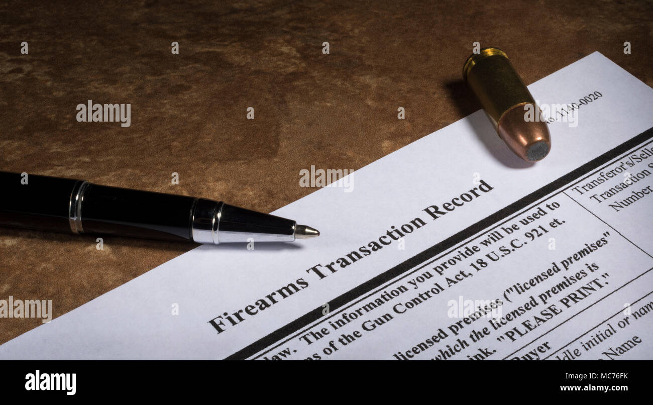 Gun paperwork for a NICS check from the FBI with a pen and cartridge ...