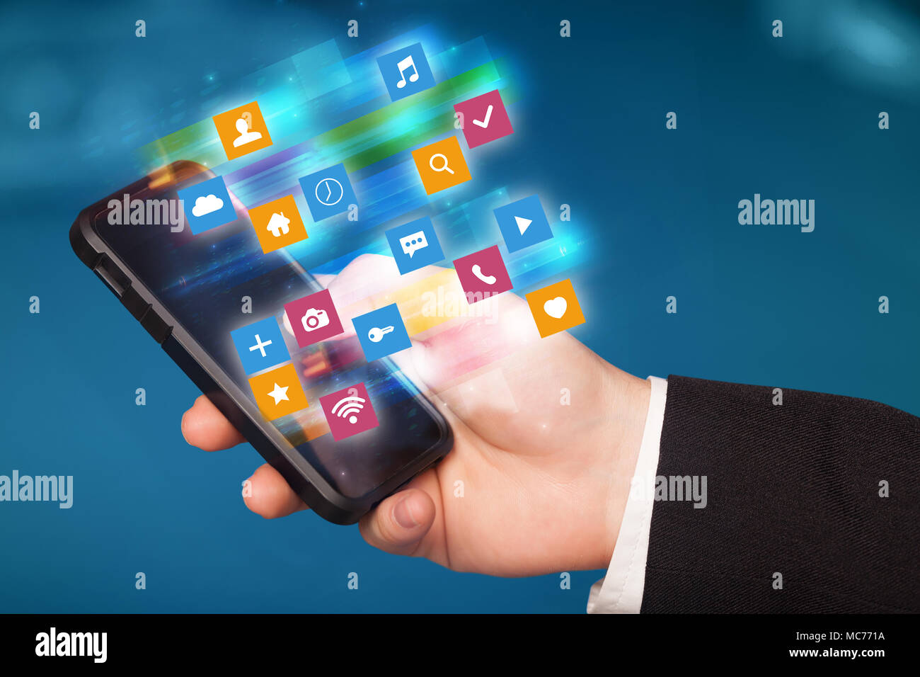 Hand using phone with colorful fast moving application icons and ...