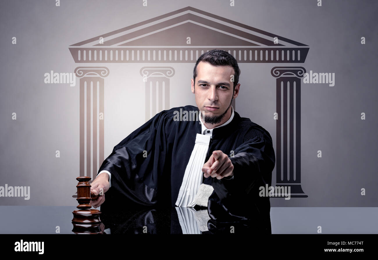 Young judge in front of a courthouse symbol making decision Stock Photo ...
