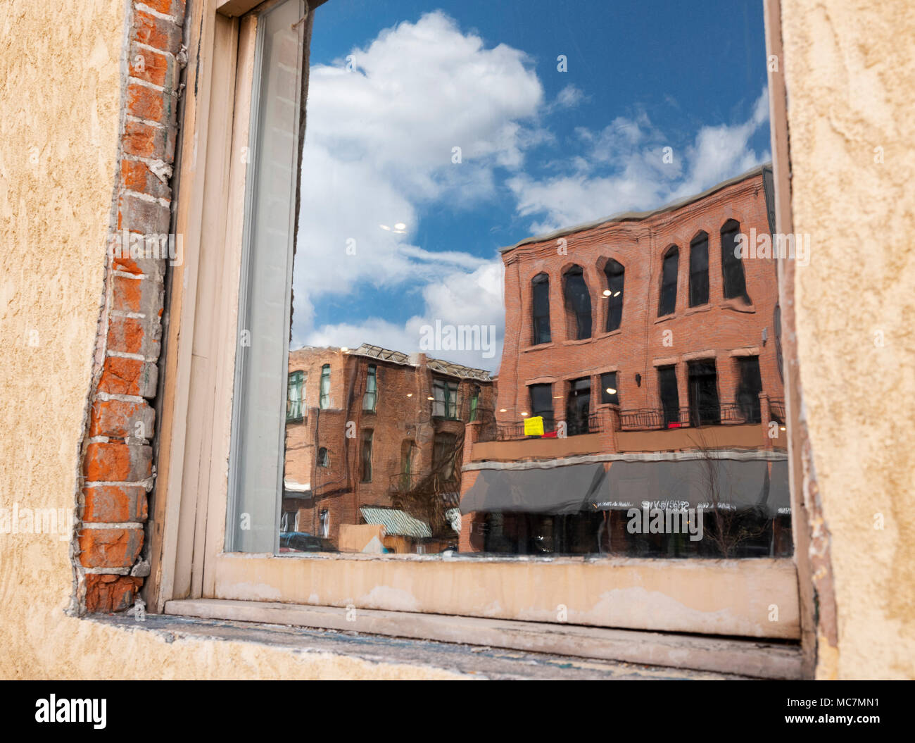Reflection in old leaded glass window of National Historic District ...