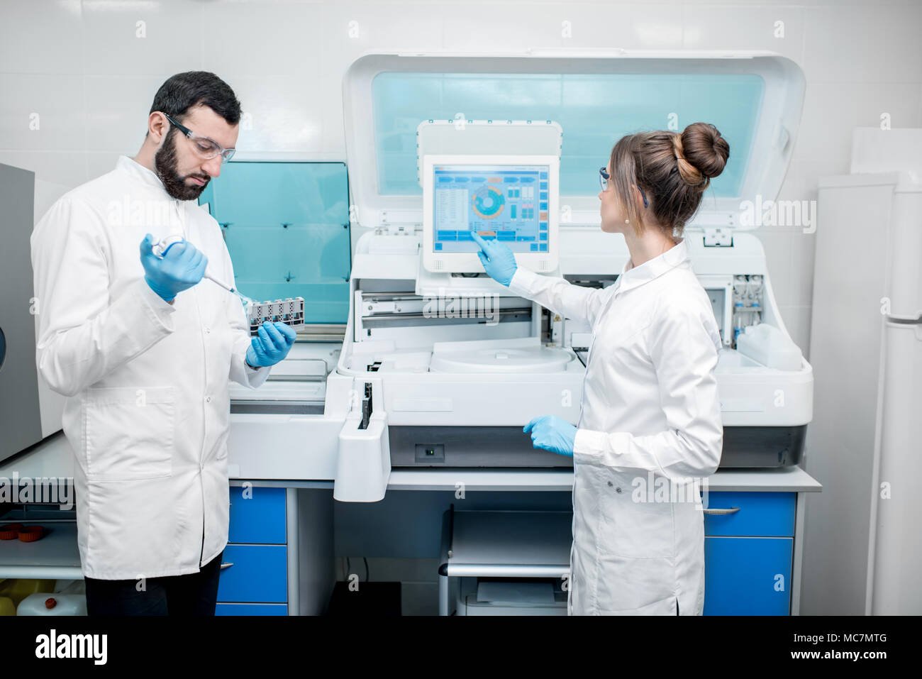 Laboratory assistants in unifrom working with professional medical ...