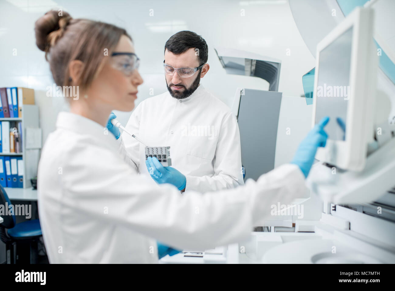 Laboratory assistants in unifrom working with professional medical ...