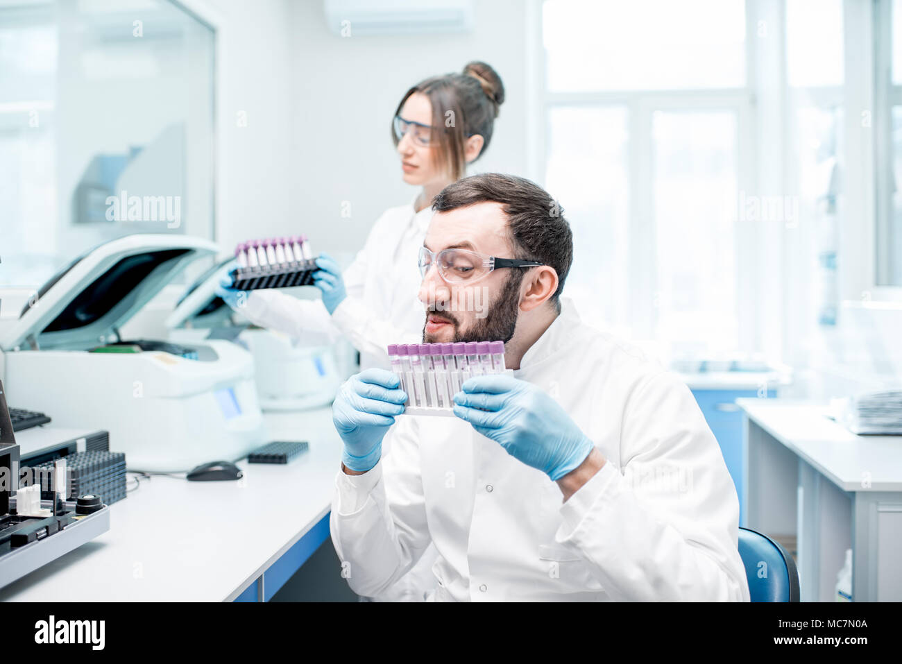 Funny portrait of a male laboratory assistant with test tubes and ...
