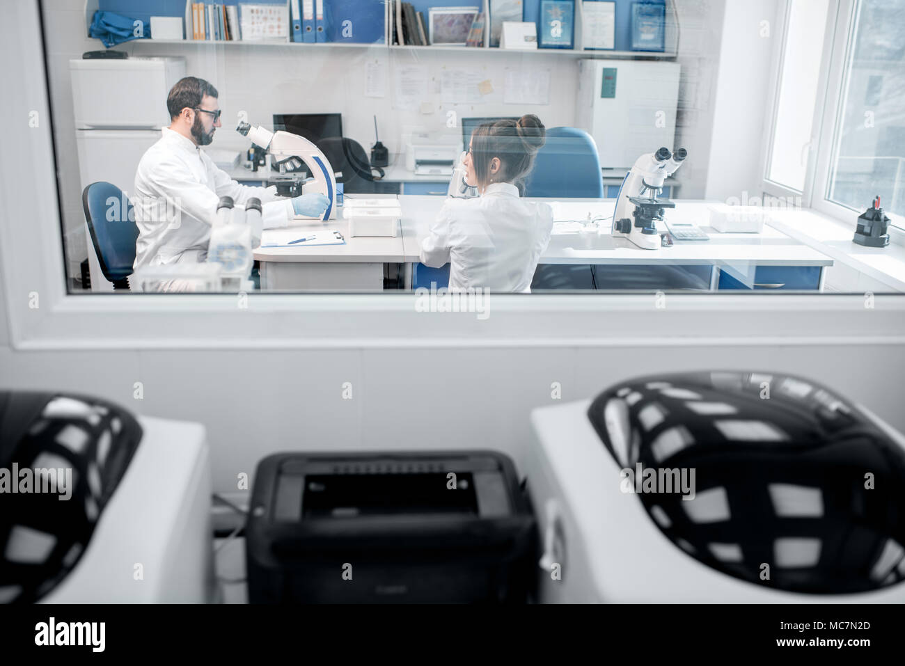 View through the window on the laboratory office with medics working ...