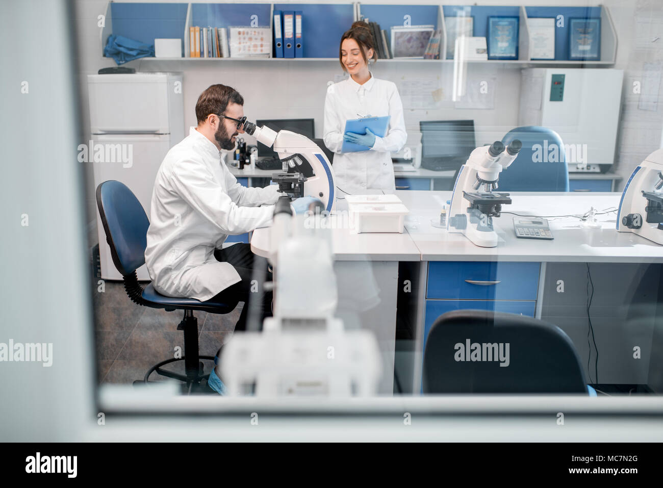 View through the window on the laboratory office with medics working ...