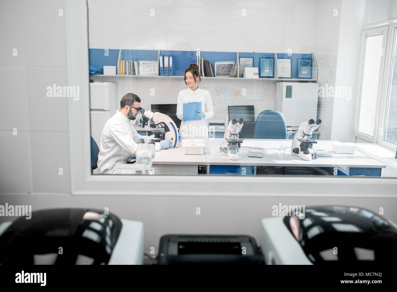 View through the window on the laboratory office with medics working ...