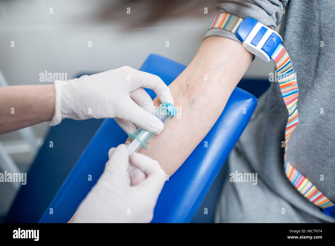 Laboratory assistant taking blood with vacuum capsule for test from the ...