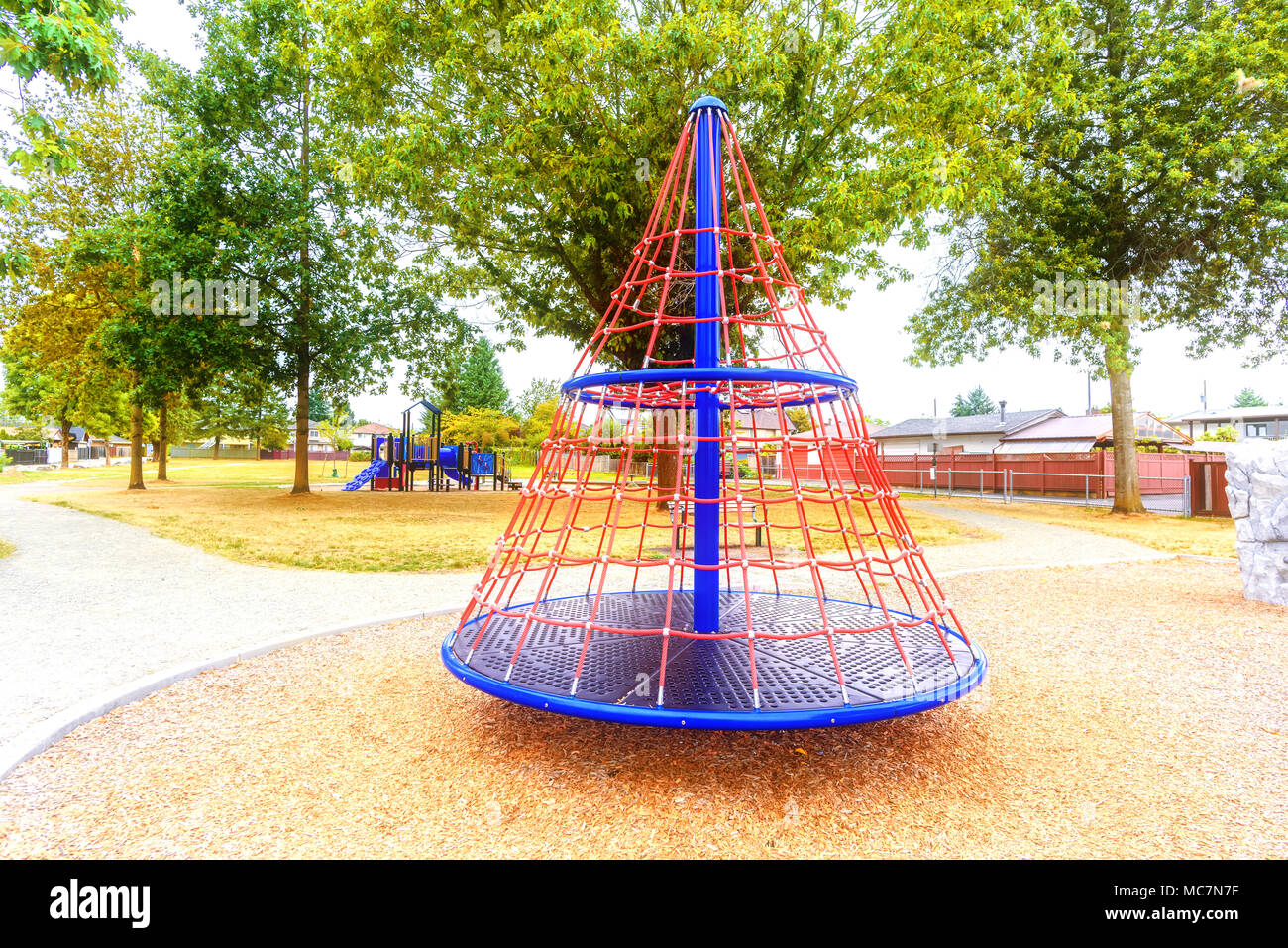 children's playground in the city park with a pyramid carousel, a hill ...
