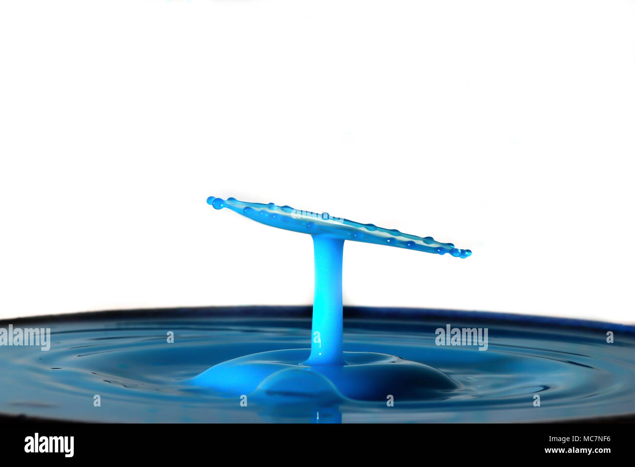 Droplet impact splash with blue crown Stock Photo - Alamy