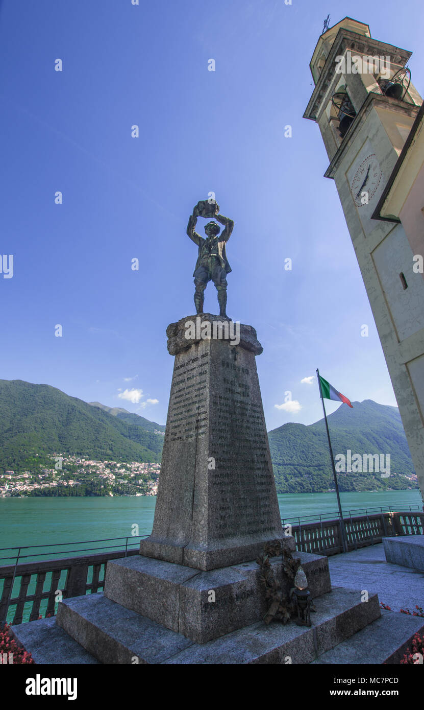 bronze monument on the square of a church in a small village of Como ...