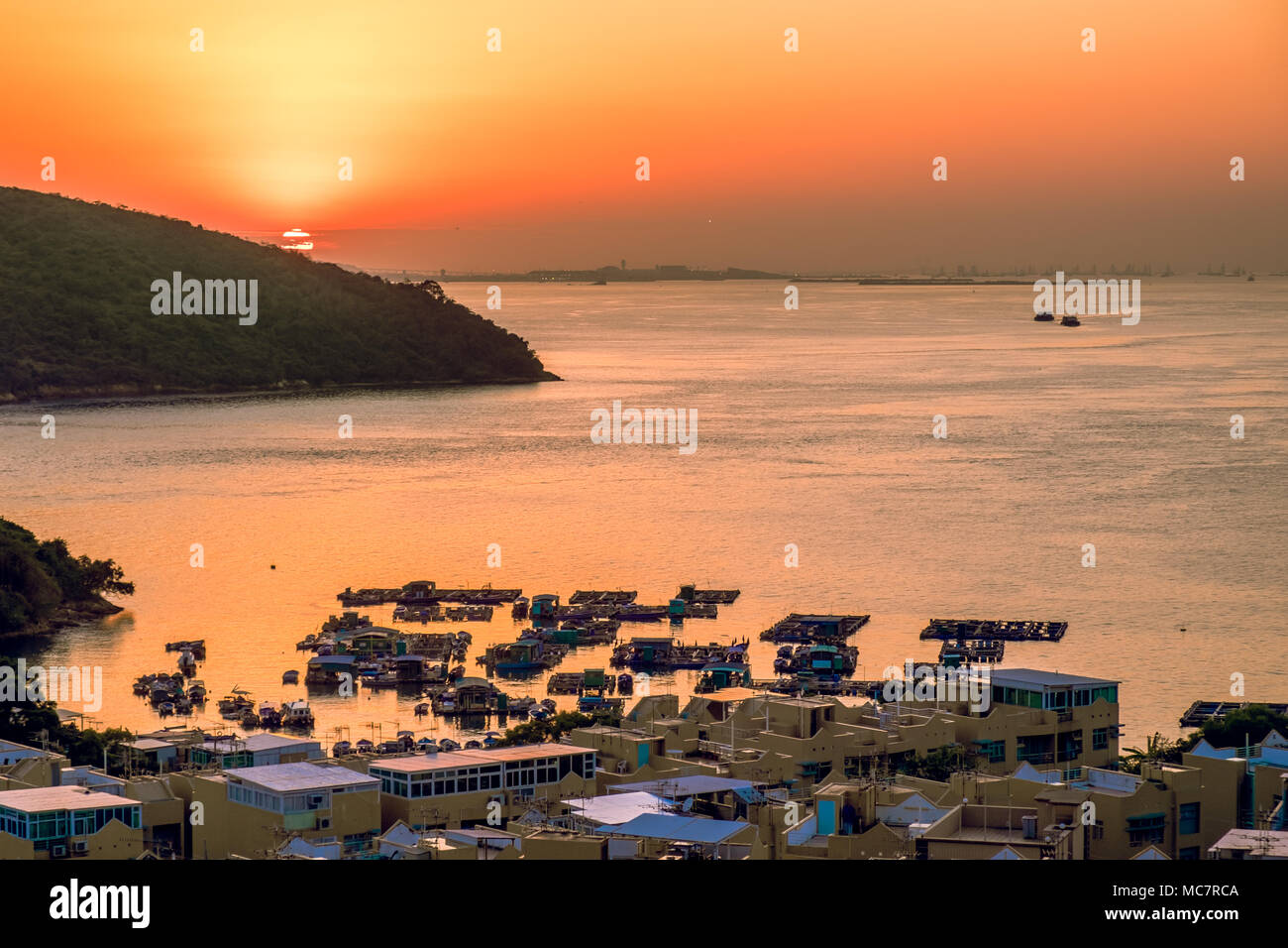 Small floating fishing farm and village houses on coastline. Beautiful ...