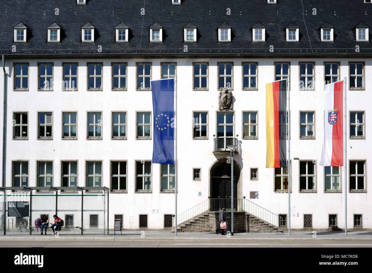 Ruesselsheim, Germany - April 11, 2018: A bus stop and various flags in ...