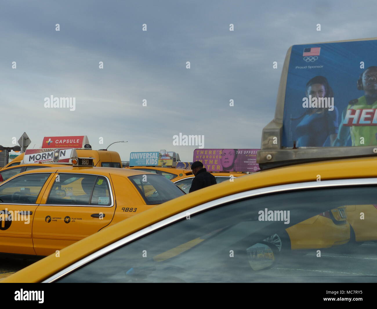 NYC taxis with rooftop advertisement waiting at JFK Central Holding Lot ...