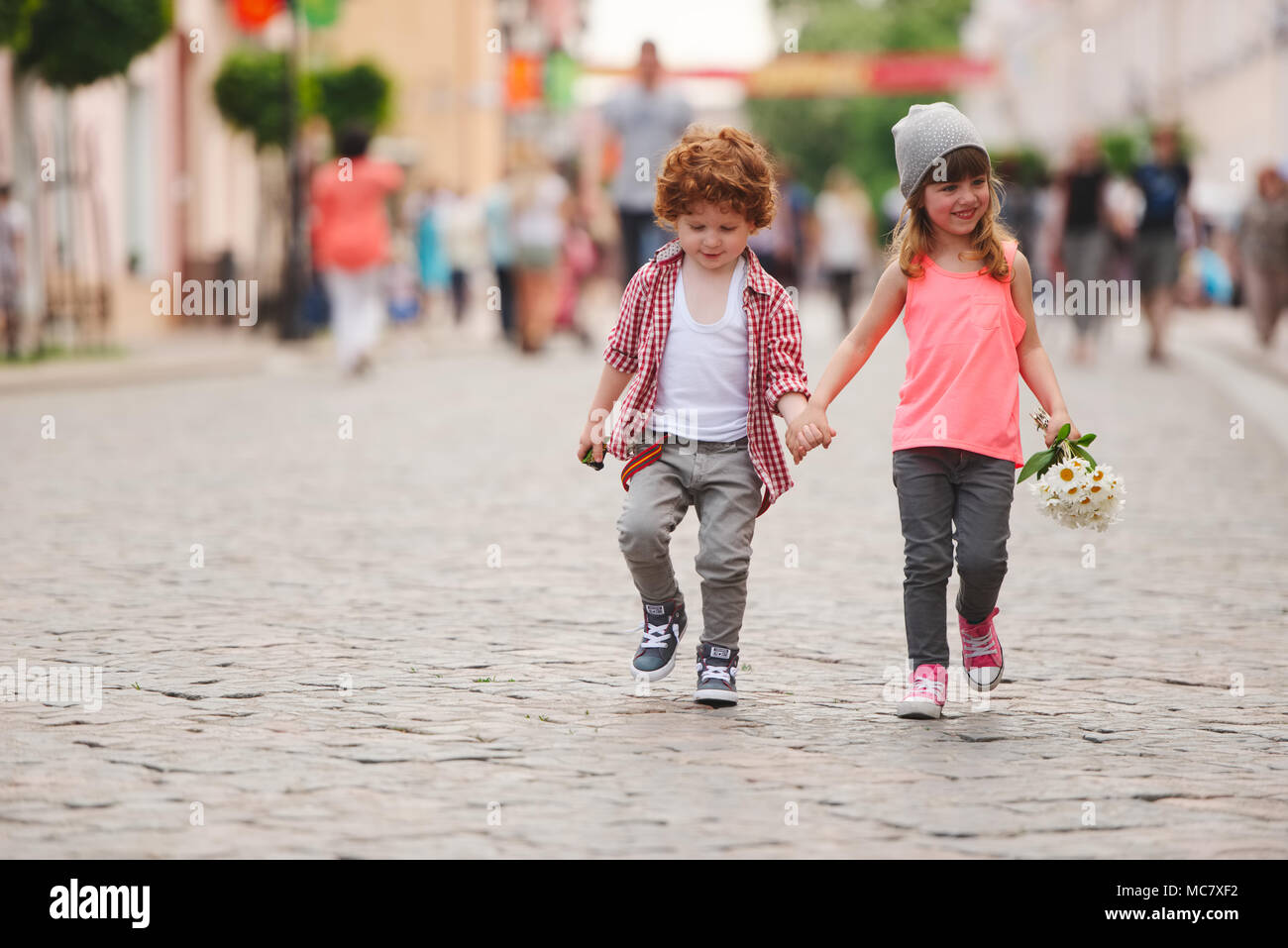 cute boy and girl walking on the street Stock Photo - Alamy