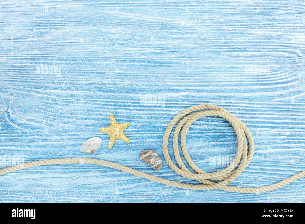 marine stones and seashells, rope on old painted blue wooden boards ...