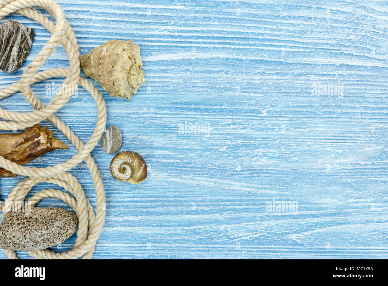 marine stones, rope and seashells on blue wooden scratched background ...
