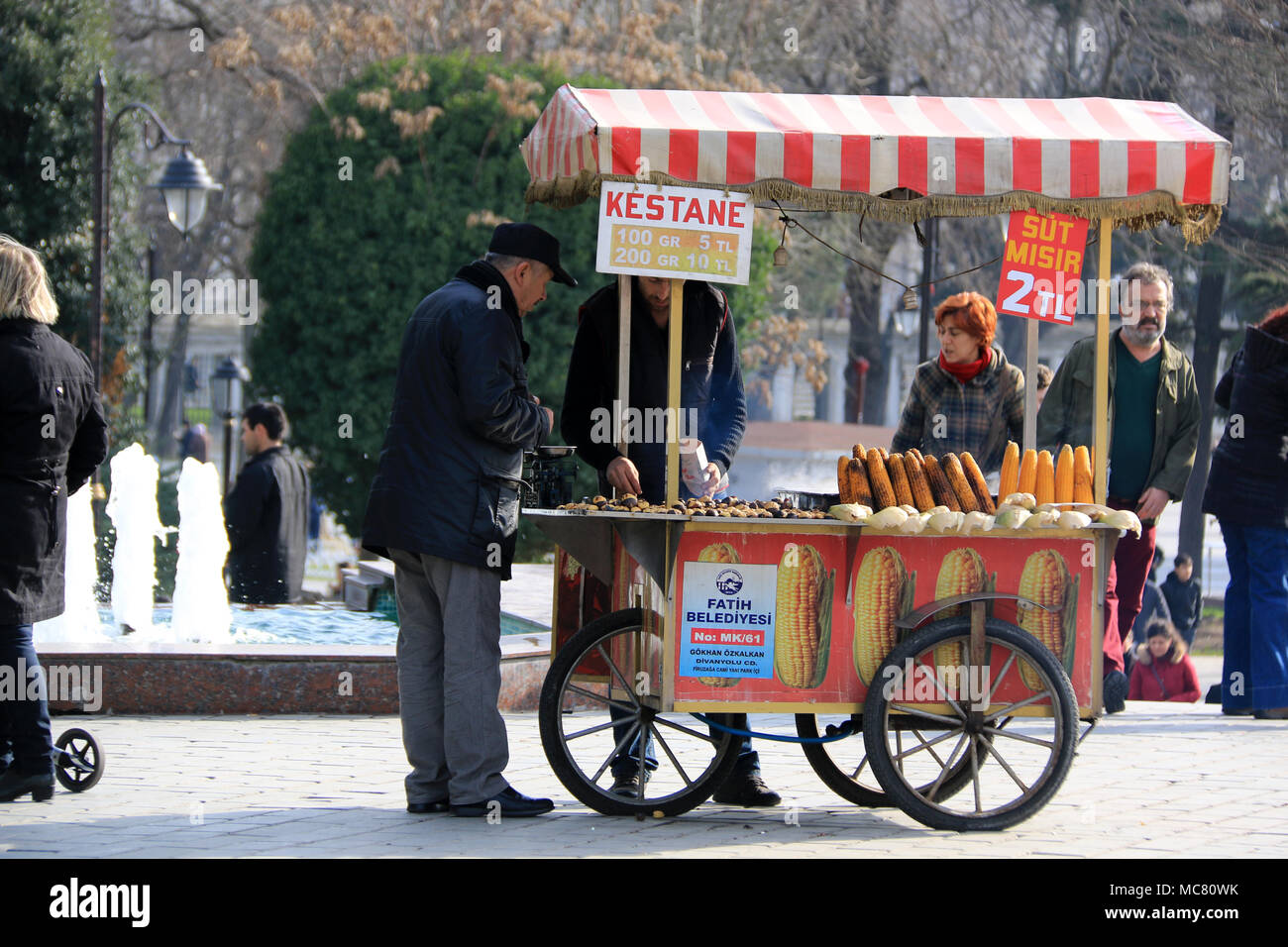 Turkish salesman selling grilled corncobs and roasted chestnuts at a ...