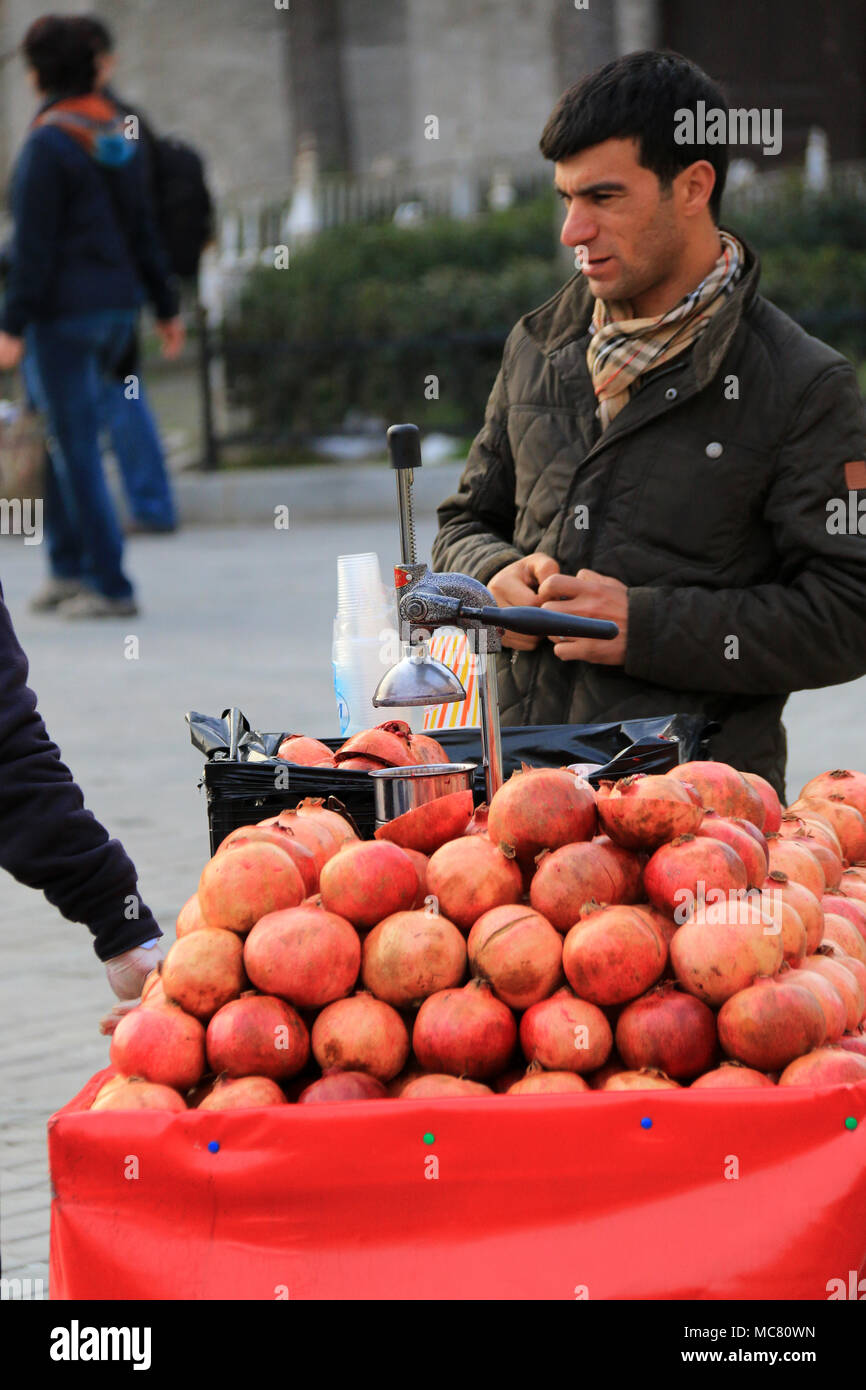 Turkish salesman selling fresh red pomegranate juice at a small street ...