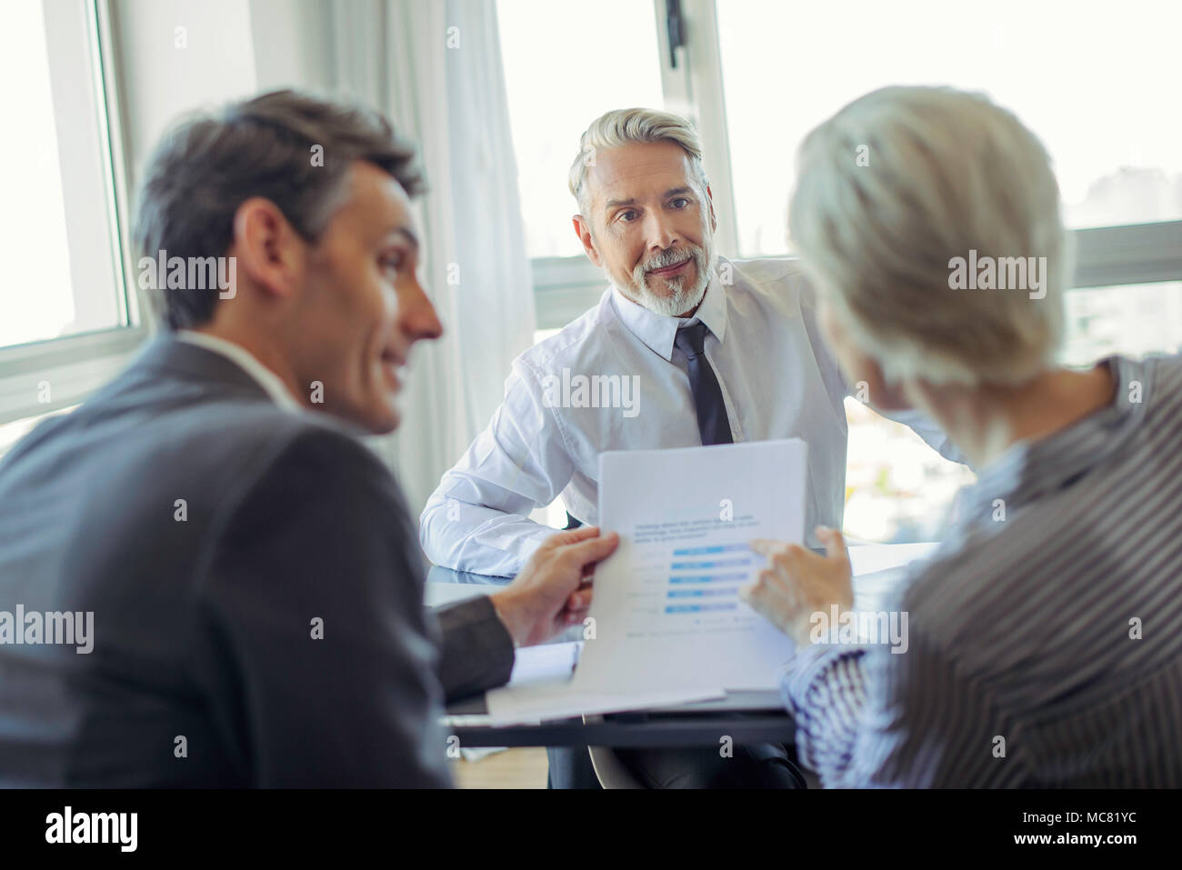 Couple reading document during meeting with businessman Stock Photo - Alamy