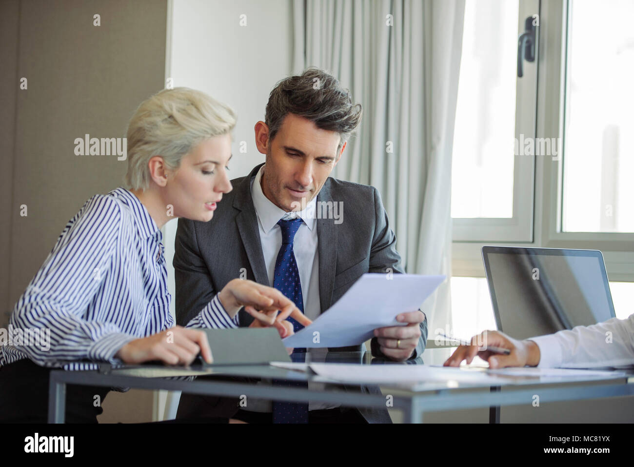 Man and woman reviewing document Stock Photo - Alamy
