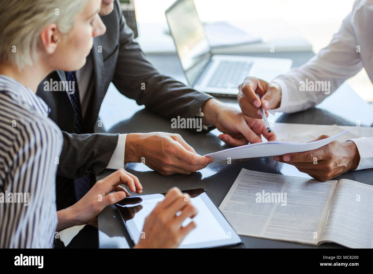 Businessman explaining document to colleagues Stock Photo - Alamy