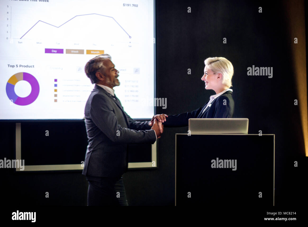Man and woman shaking hands at podium Stock Photo - Alamy