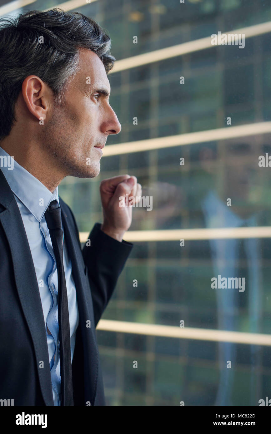 Man looking through window in high rise building Stock Photo - Alamy