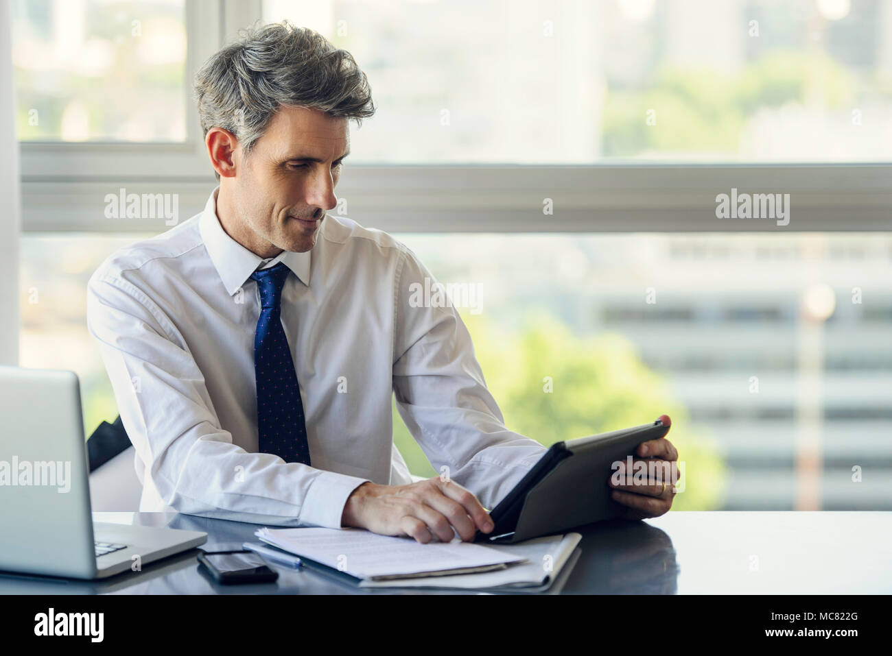 Focused professional using tablet in hi-res stock photography and ...