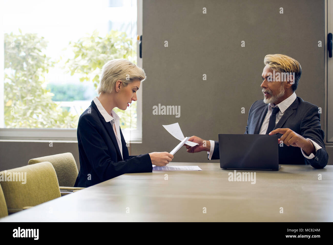Woman and man in office reading document Stock Photo - Alamy