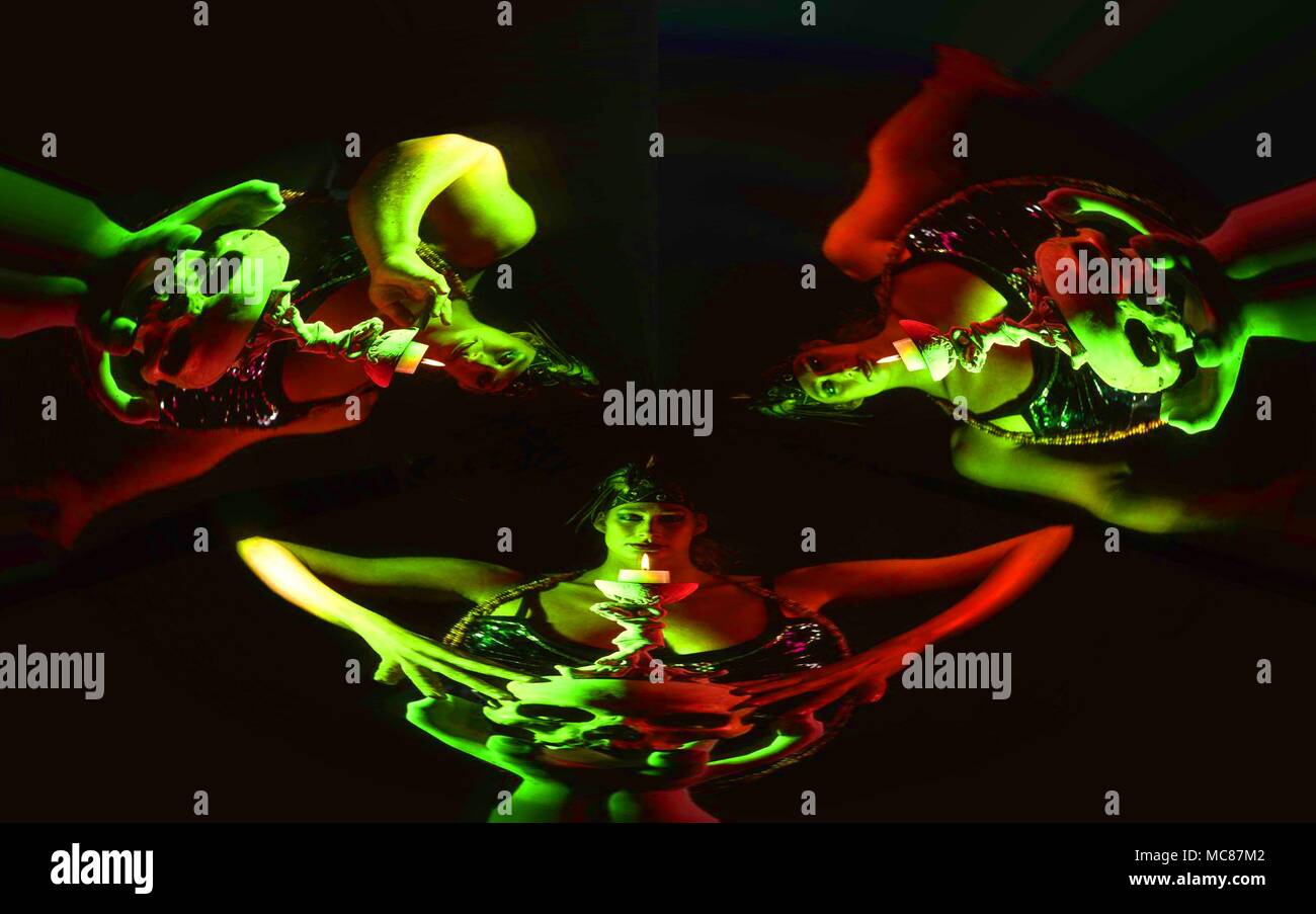 Wiccan priestess involved in three stages of candle magic. Distorted ...