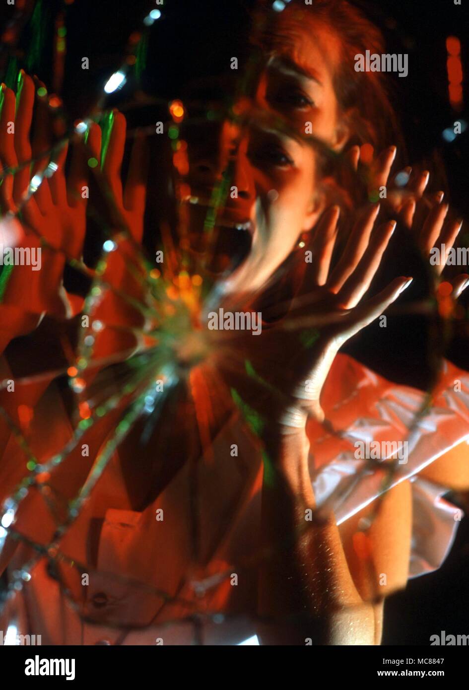 Fantasy - fear. A girl screaming into a broken mirror Stock Photo - Alamy